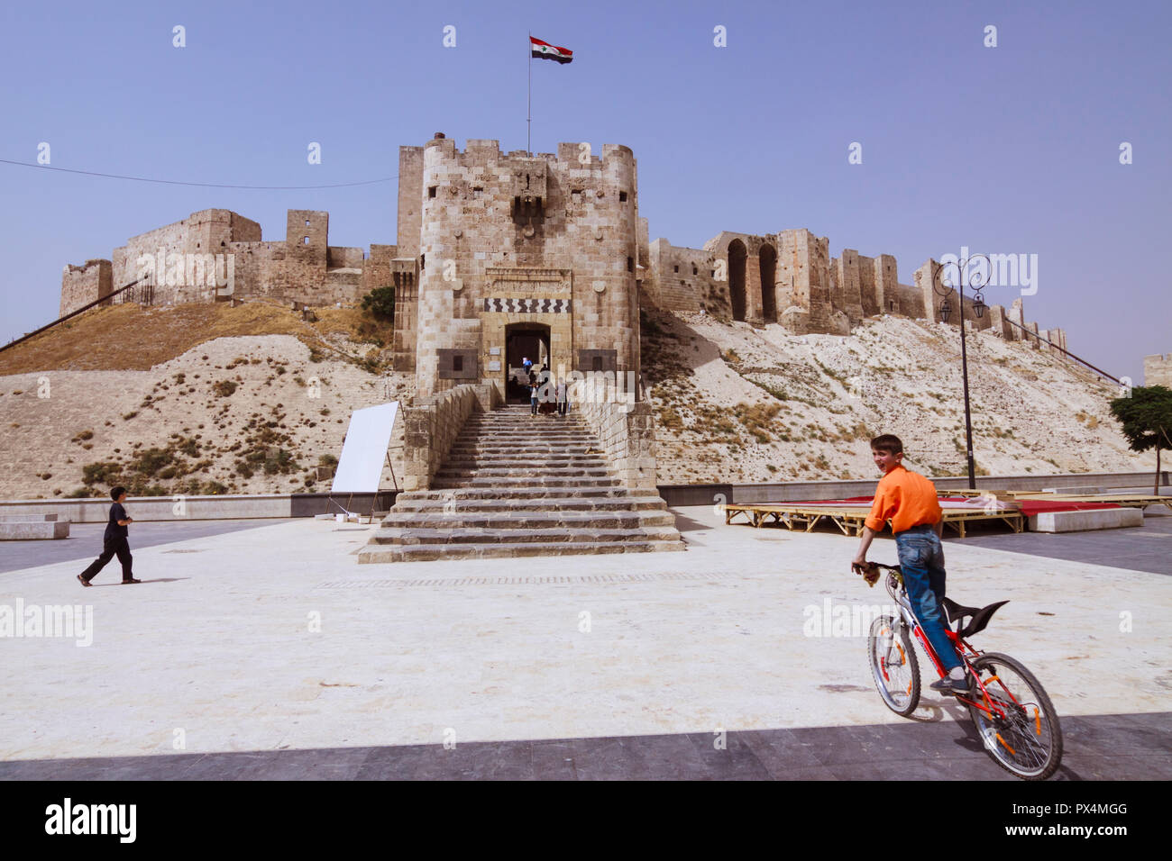 Aleppo, Aleppo Governorate, Syria : A boy cycles past the Citadel of ...
