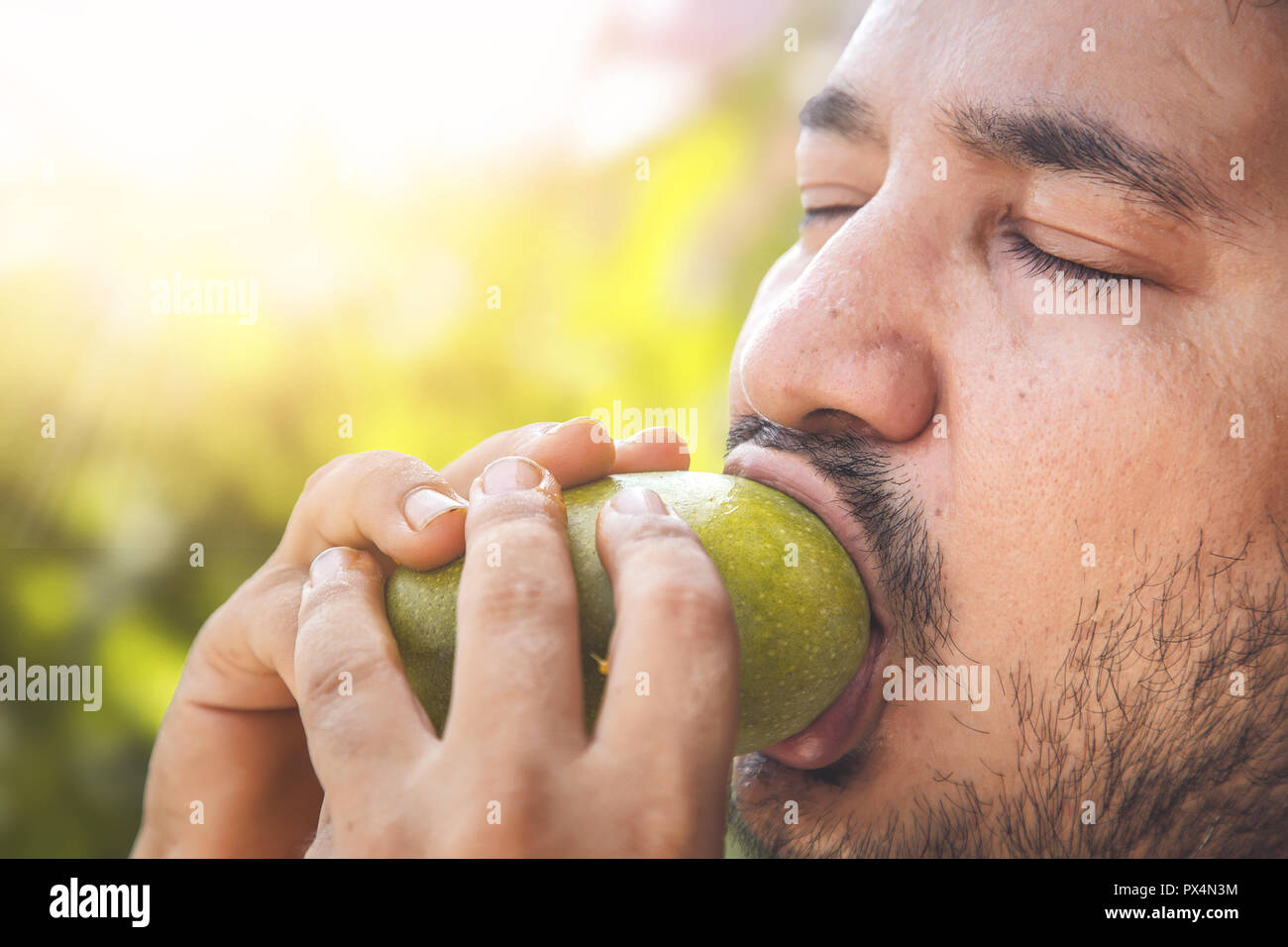 Indian man eating mango Stock Photo - Alamy