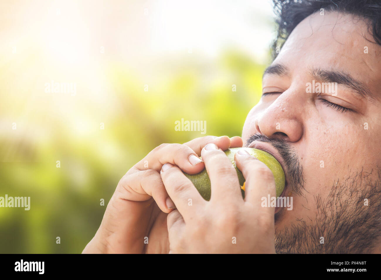 Indian man eating mango Stock Photo - Alamy