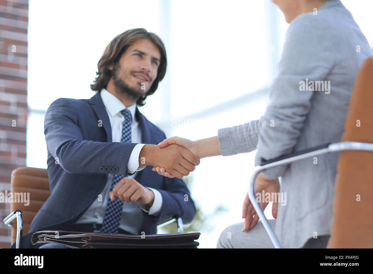 Business partners handshaking over business objects on workplace Stock ...
