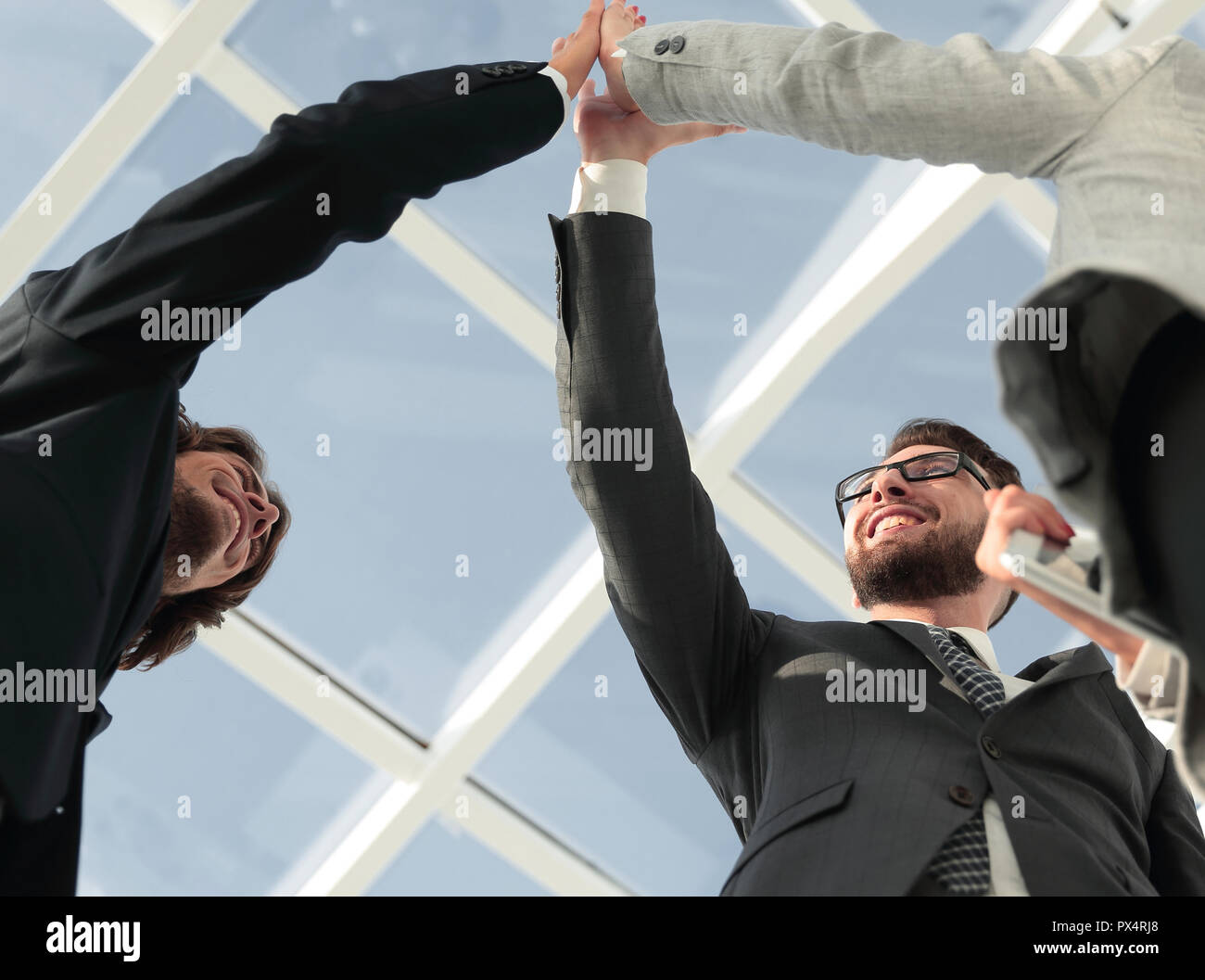 Happy business team giving high five in office Stock Photo - Alamy