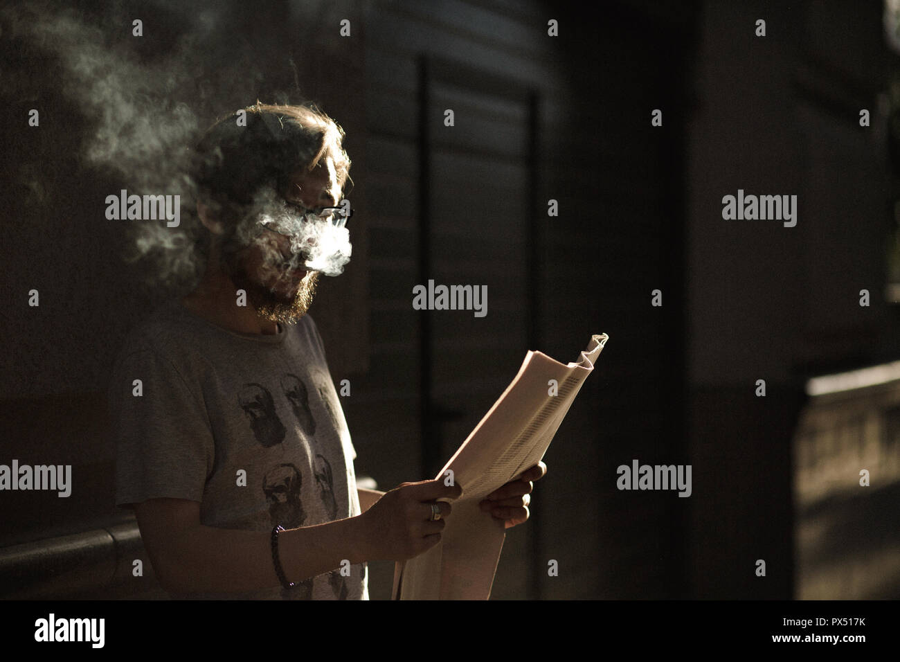 Man reading a newspaper on the street Stock Photo - Alamy
