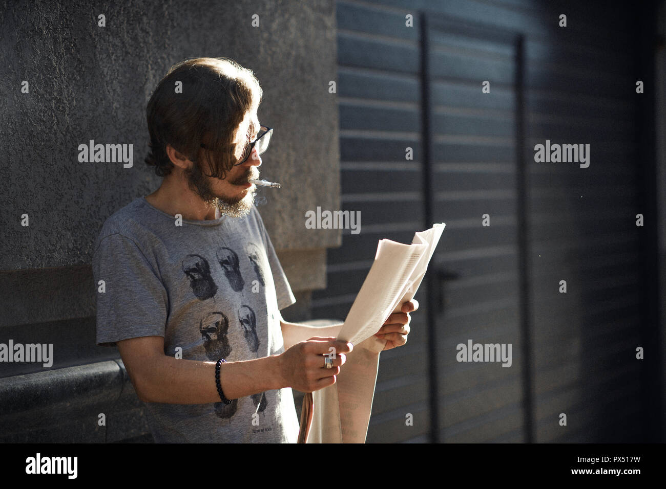 Man reading a newspaper on the street Stock Photo - Alamy