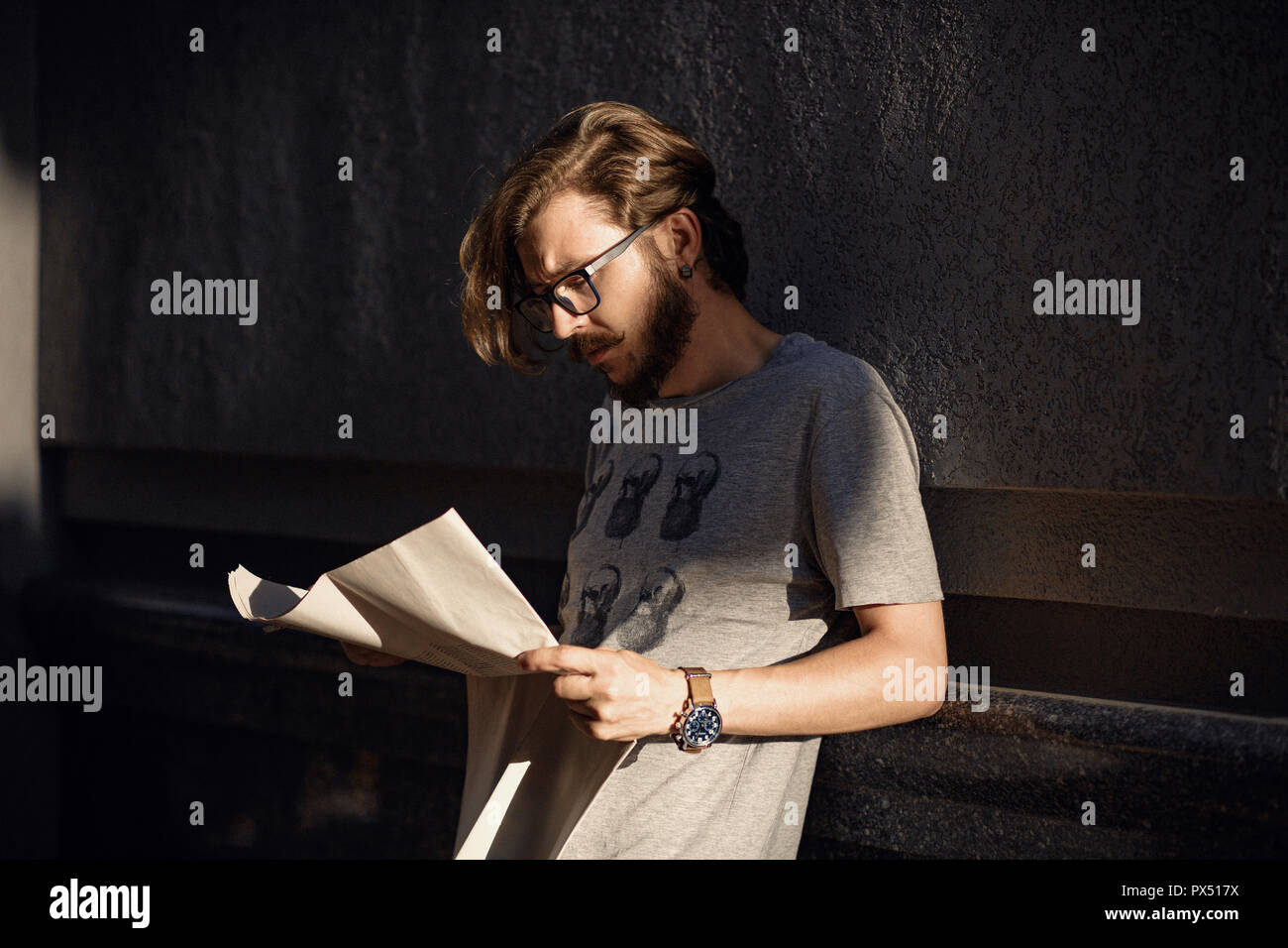 Man reading a newspaper on the street Stock Photo - Alamy