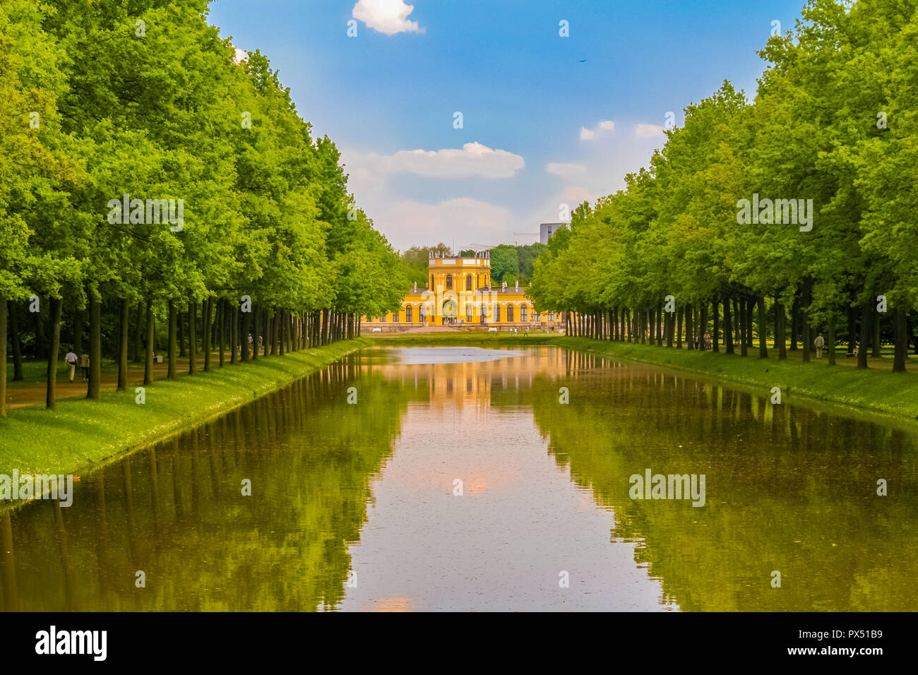 Picturesque view of a water channel with tree avenues left & right and ...