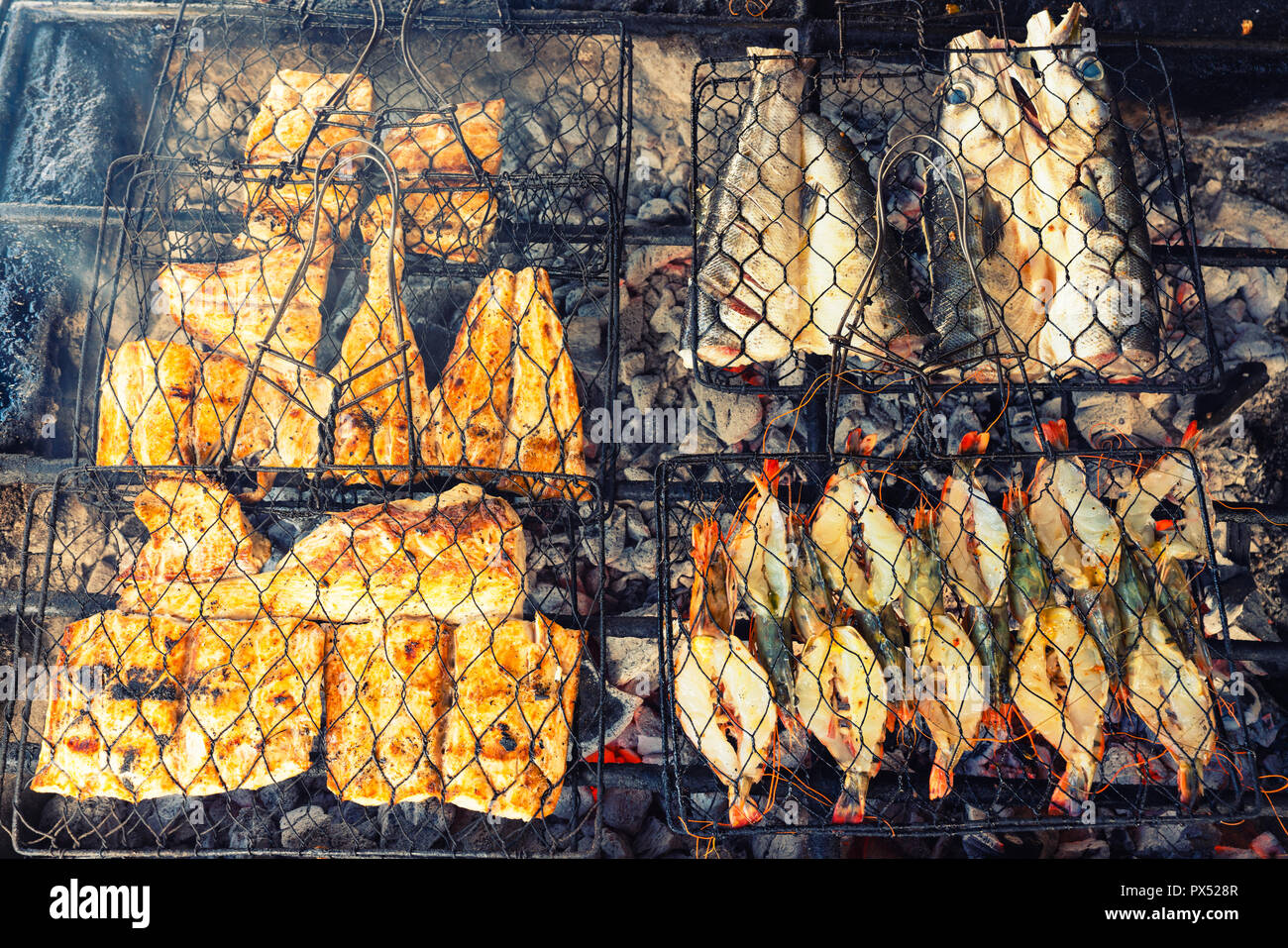 Cooking grilled fresh BBQ seafood on fire: prawns, fish, food ...