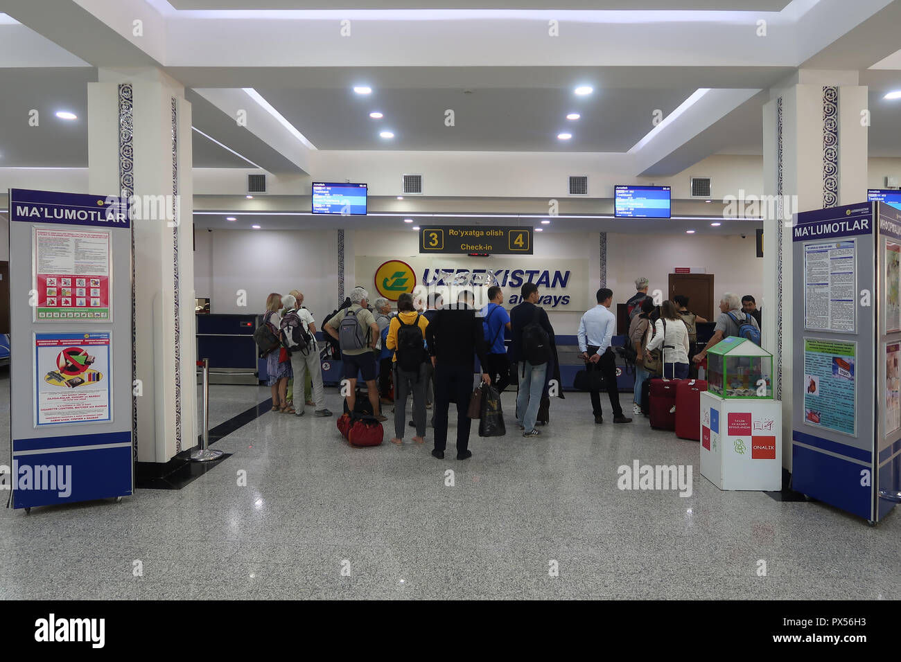 Passengers wait in line at a check in counter in Urgench International ...