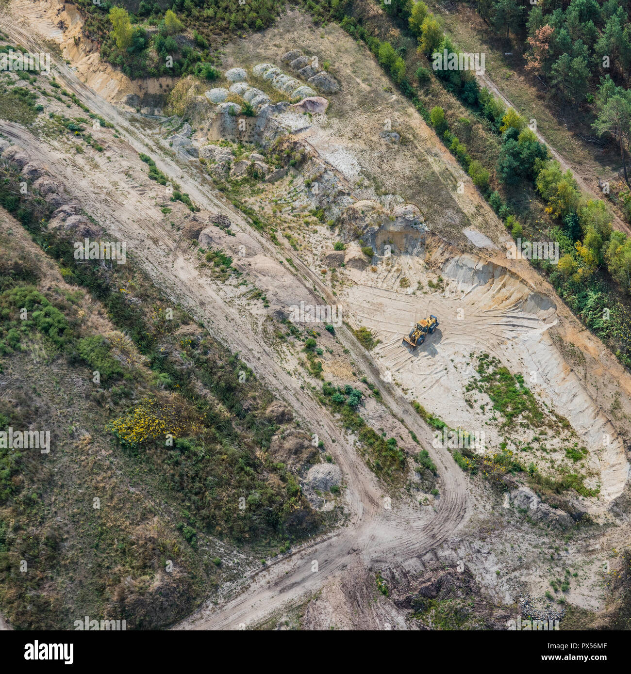 Vertical aerial view of a sand quarry in the heath with a wheel loader ...