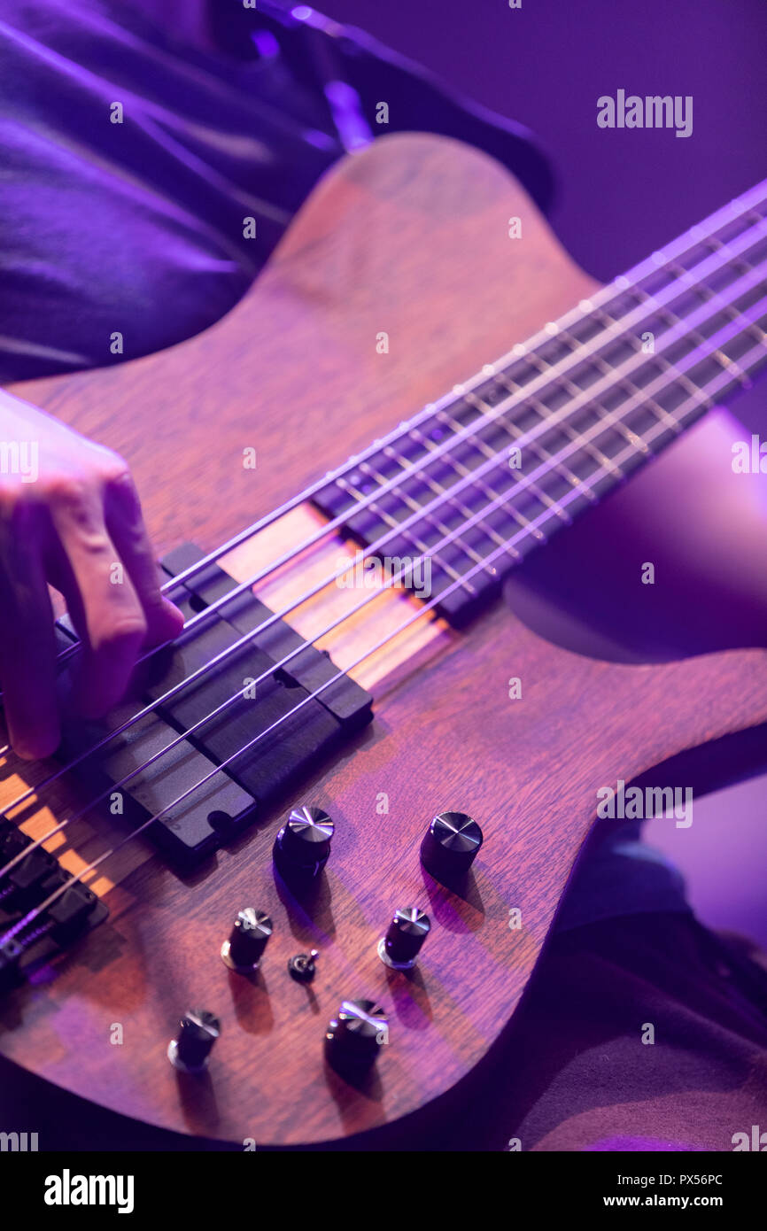 A base guitar player playing an electric base Stock Photo - Alamy