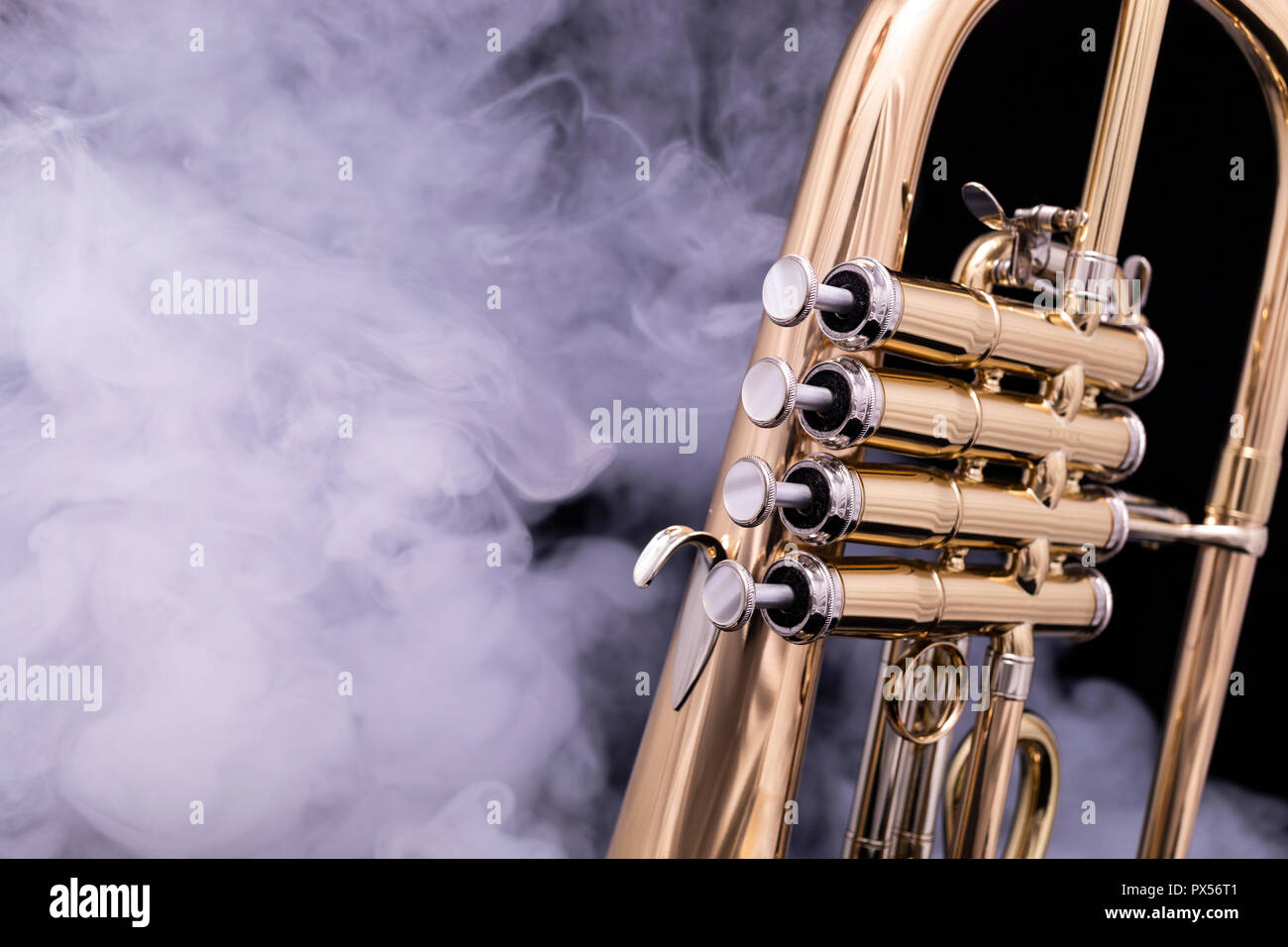 A four valve lacquered flugelhorn in smoke on a black background Stock ...