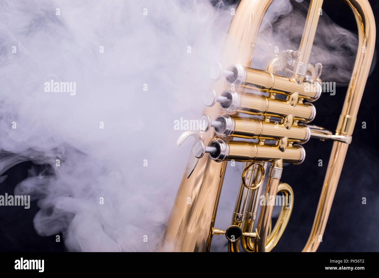 A four valve lacquered flugelhorn in smoke on a black background Stock ...