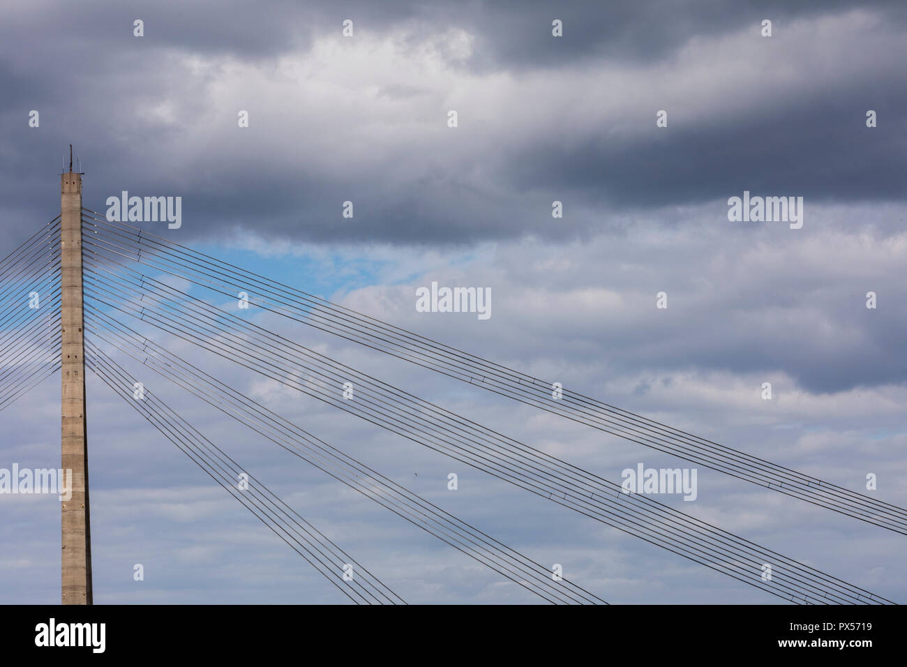 A part of a bridge with wires on a cloudy background Stock Photo - Alamy