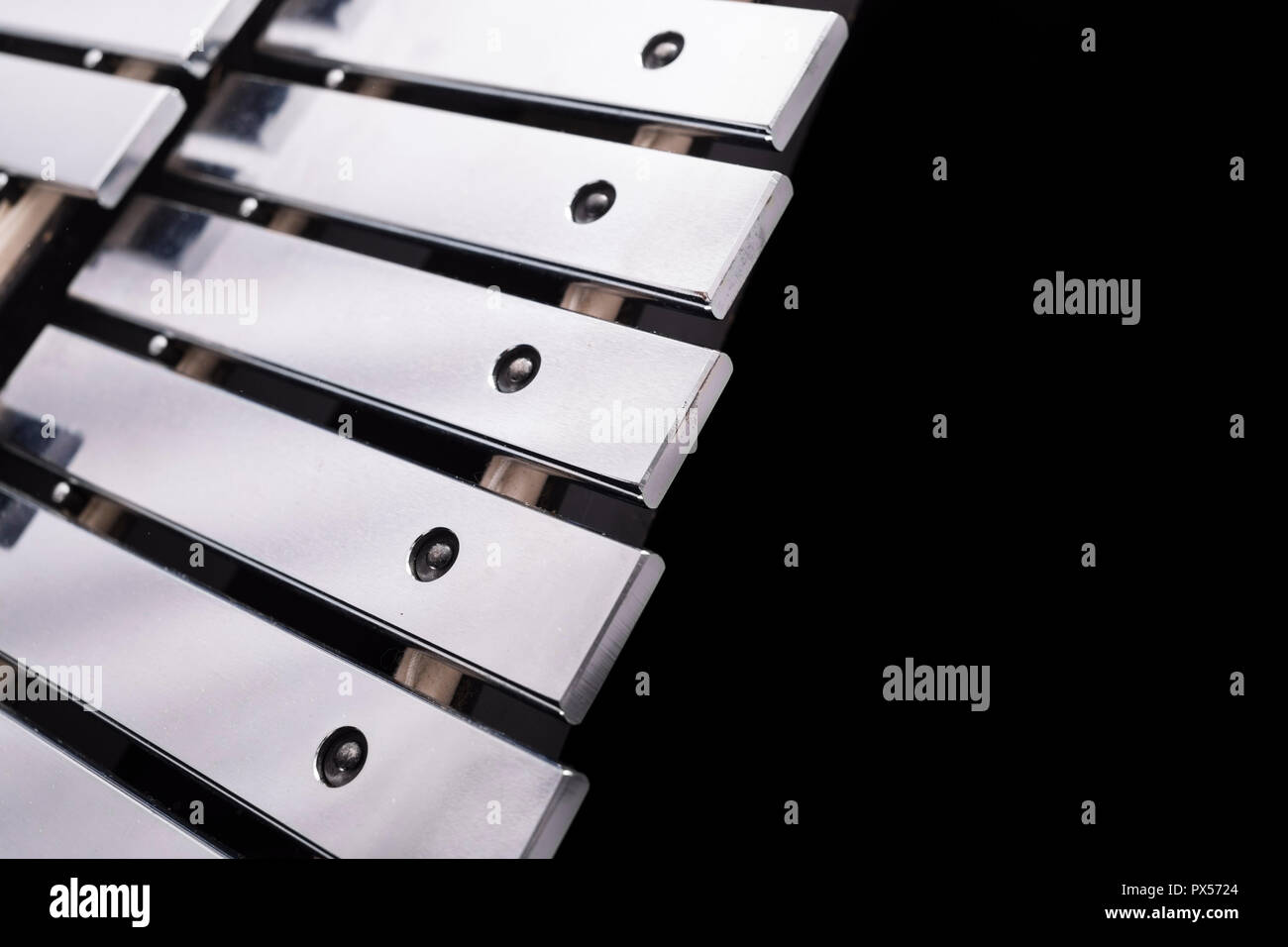 A part of a metal xylophone on a black background Stock Photo - Alamy