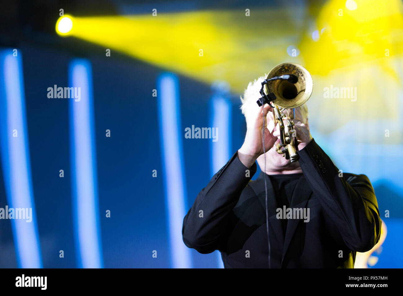 A trumpet player performing in a concert with stage lights in the ...