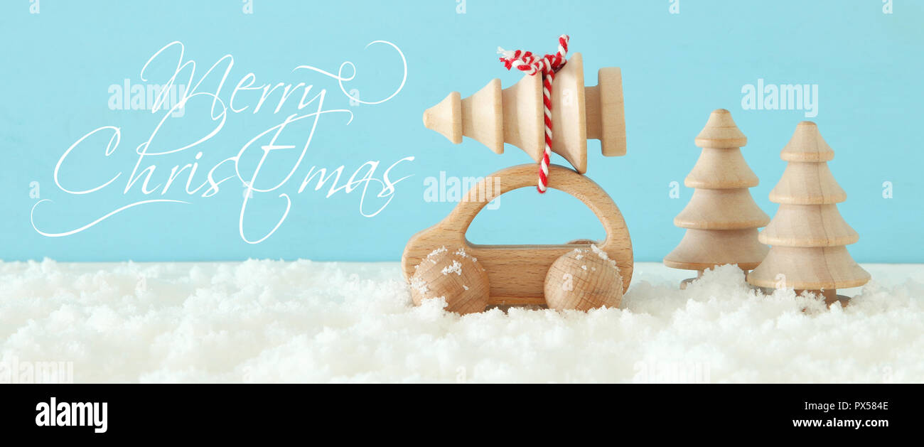 Wooden car carrying a christmas tree in front of blue background Stock ...