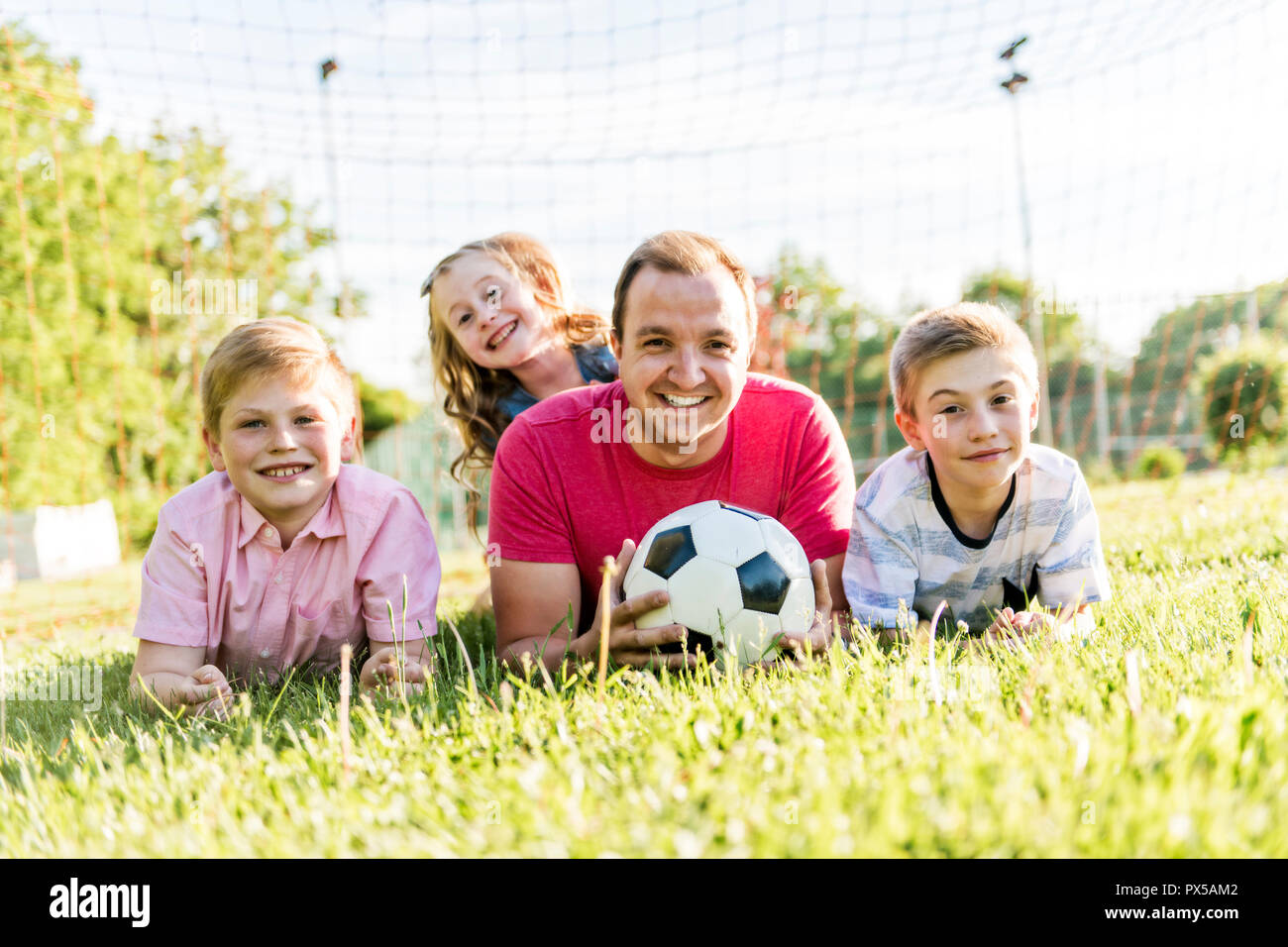 Happy family lifestyle play soccer outside Stock Photo - Alamy