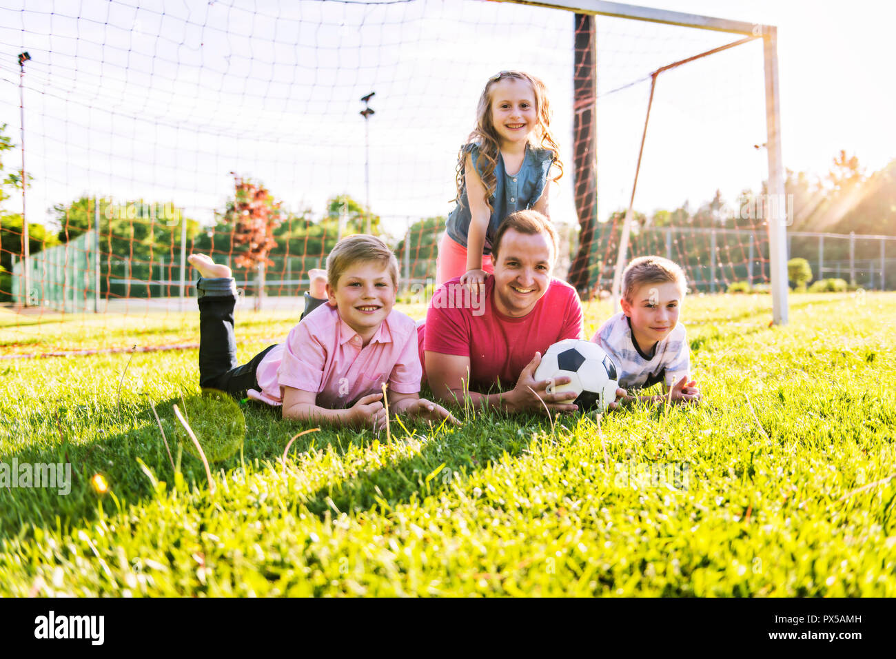 Happy family lifestyle play soccer outside Stock Photo - Alamy