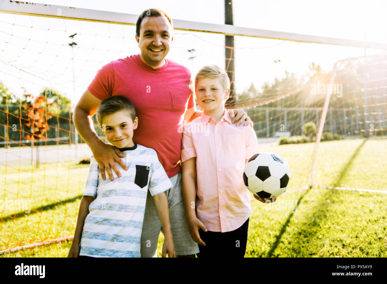 man with child playing football outside on field Stock Photo - Alamy