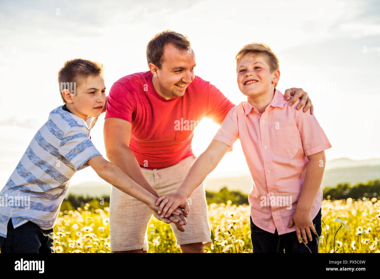 Father spending time with two sons during the sunset Stock Photo - Alamy