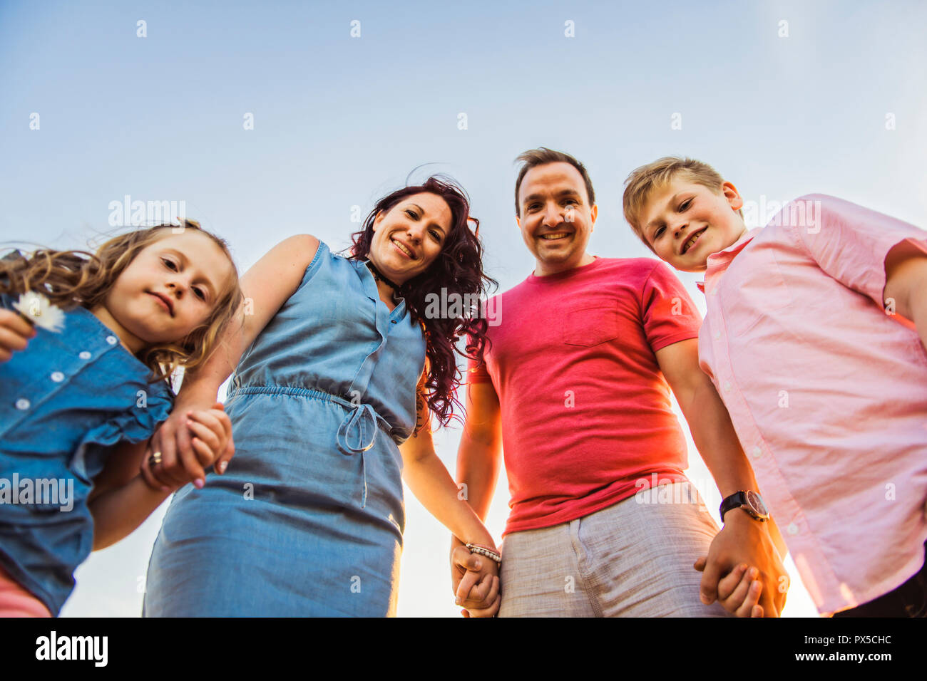 Happy family having fun on daisy field at sunset Stock Photo - Alamy