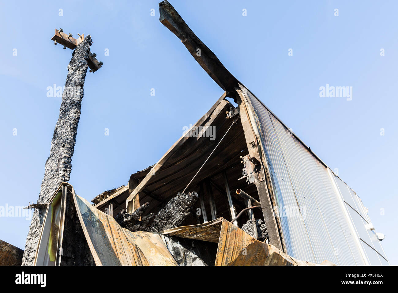 Damaged roof industry supermarket after arson fire with burn debris of ...