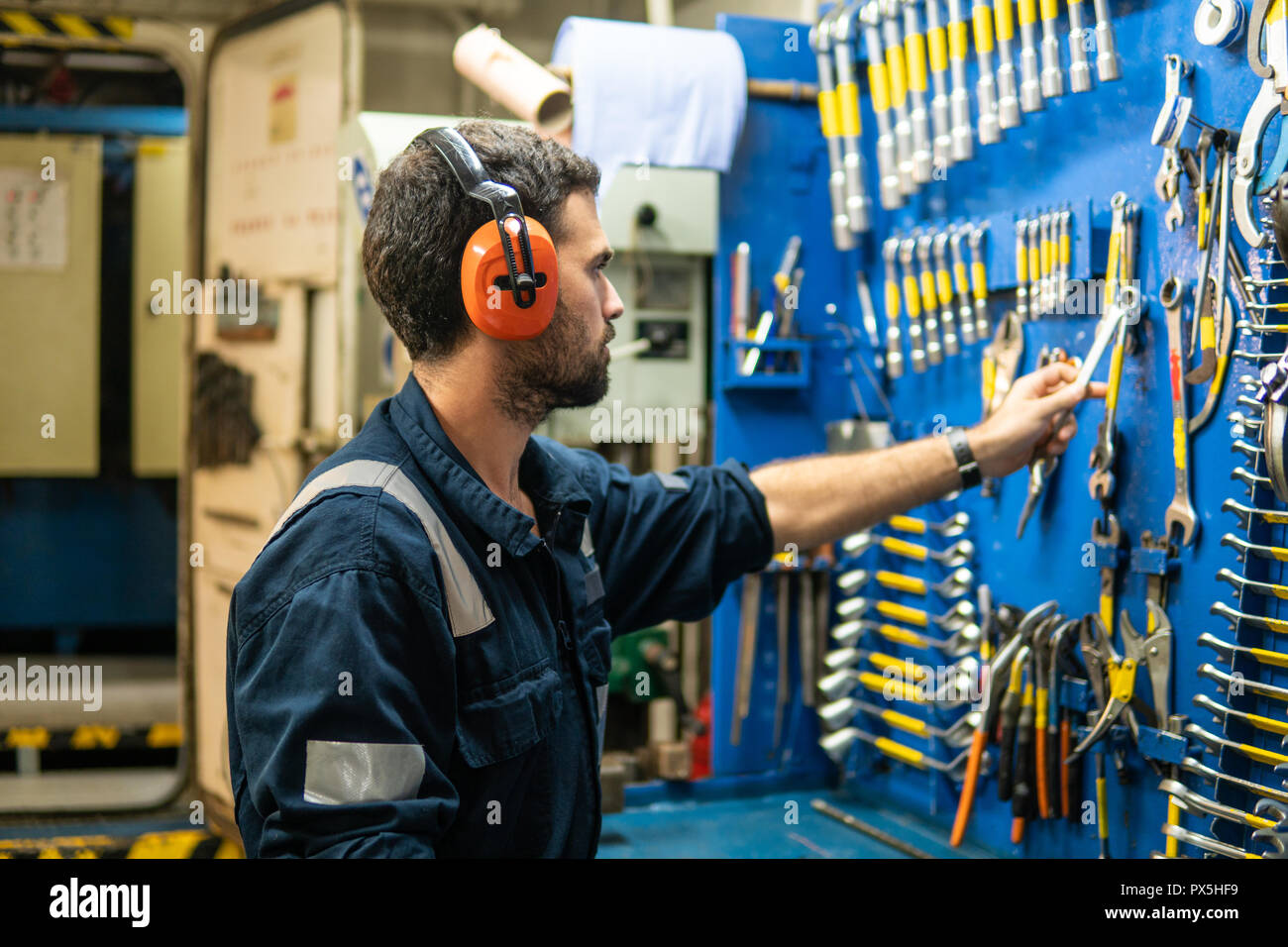 Marine engineer officer working in engine room Stock Photo - Alamy