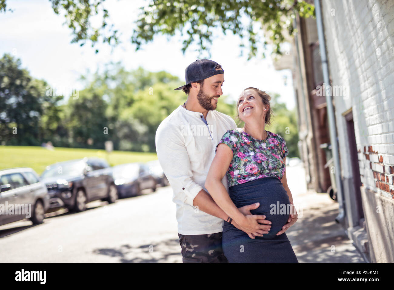 A Pregnant couple portrait outside in the neighborhood Stock Photo - Alamy