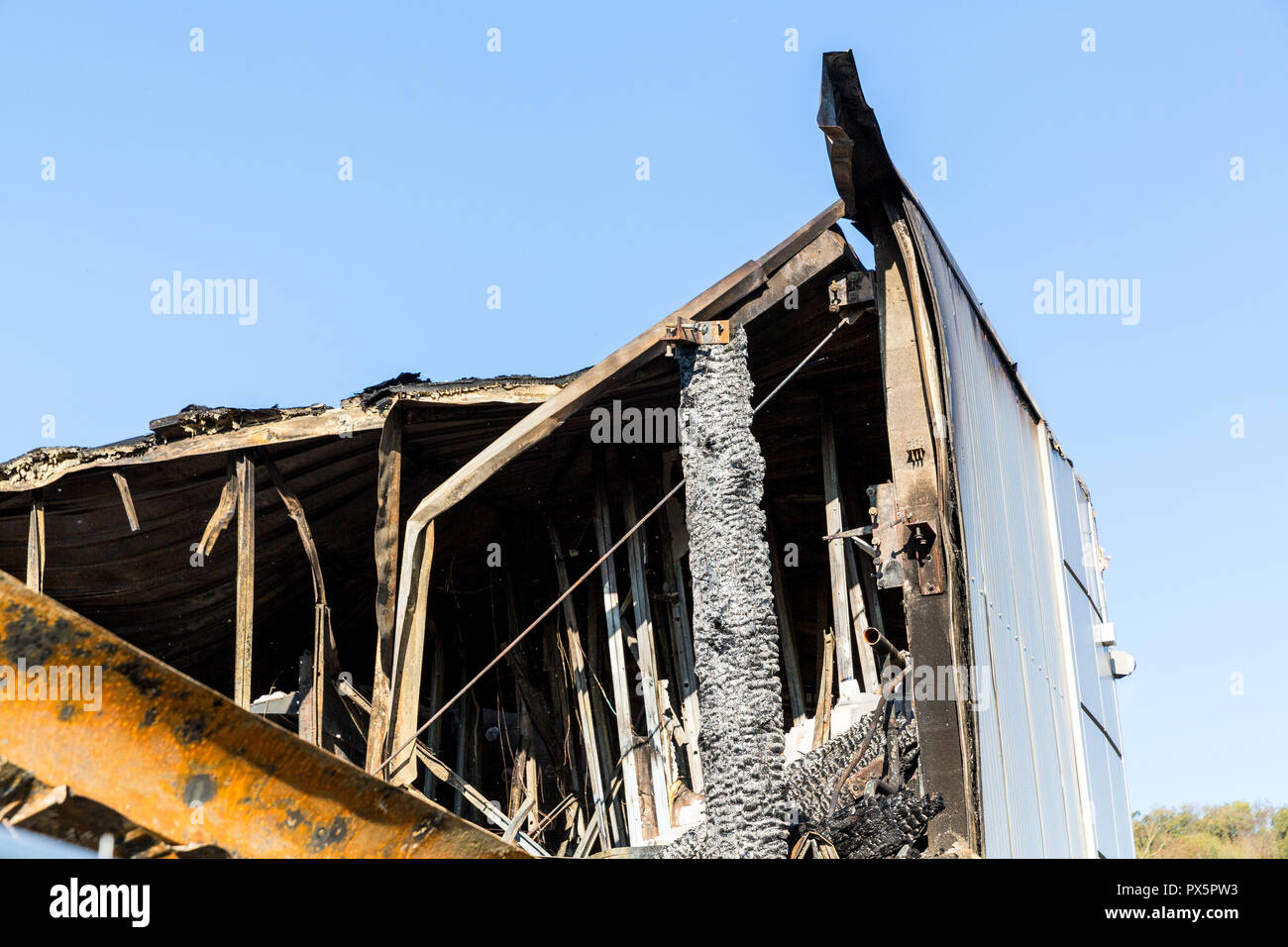 Damaged roof industry supermarket after arson fire with burn debris of ...