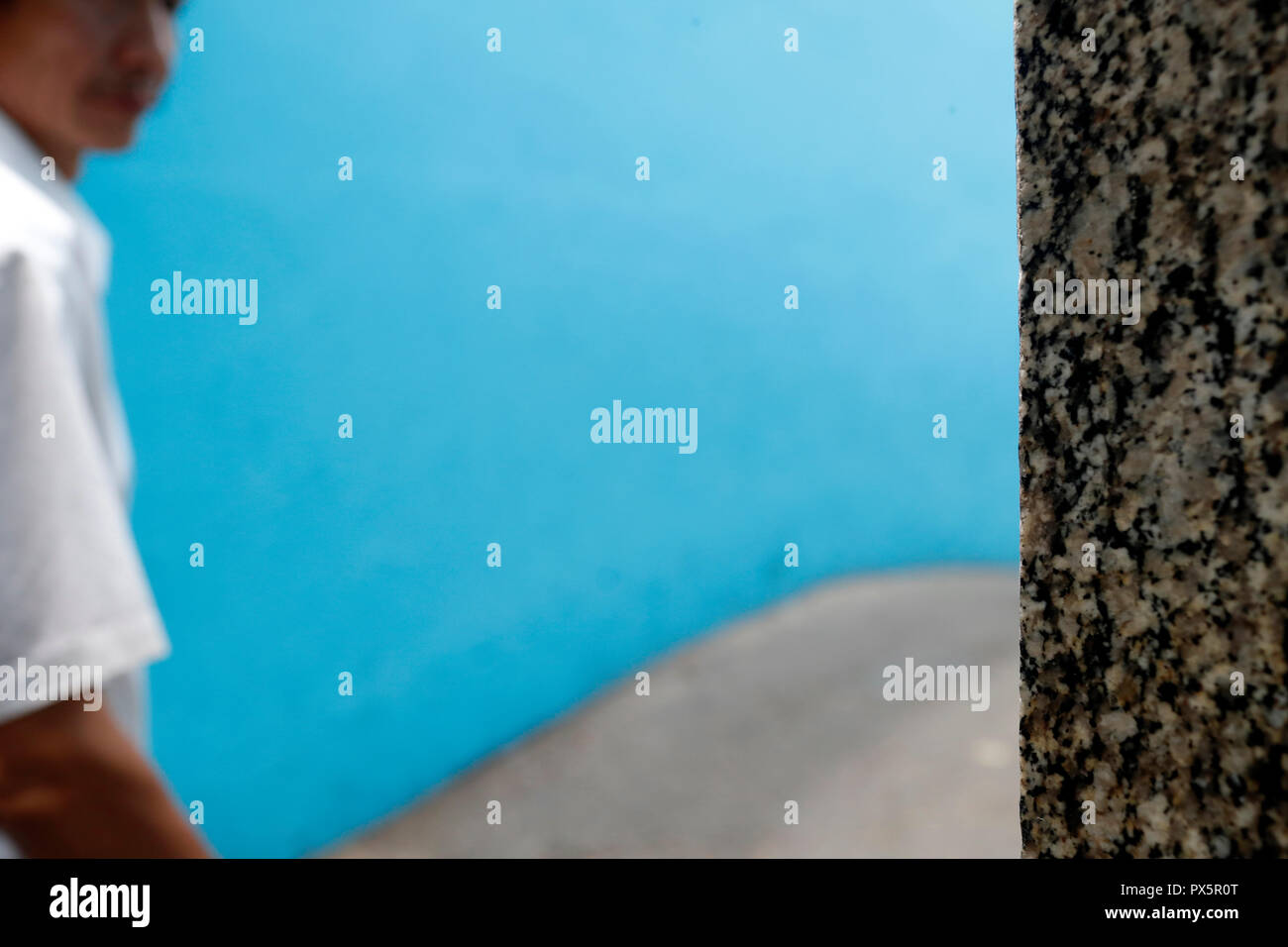 Man walking against blue wall hi-res stock photography and images - Alamy