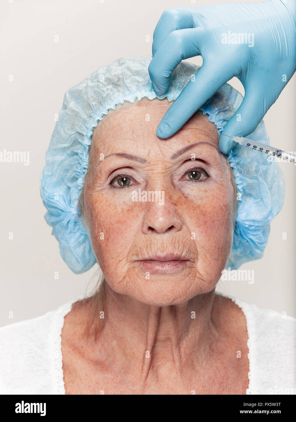 The surgeon doing skin check on mid age woman before plastic surgery ...