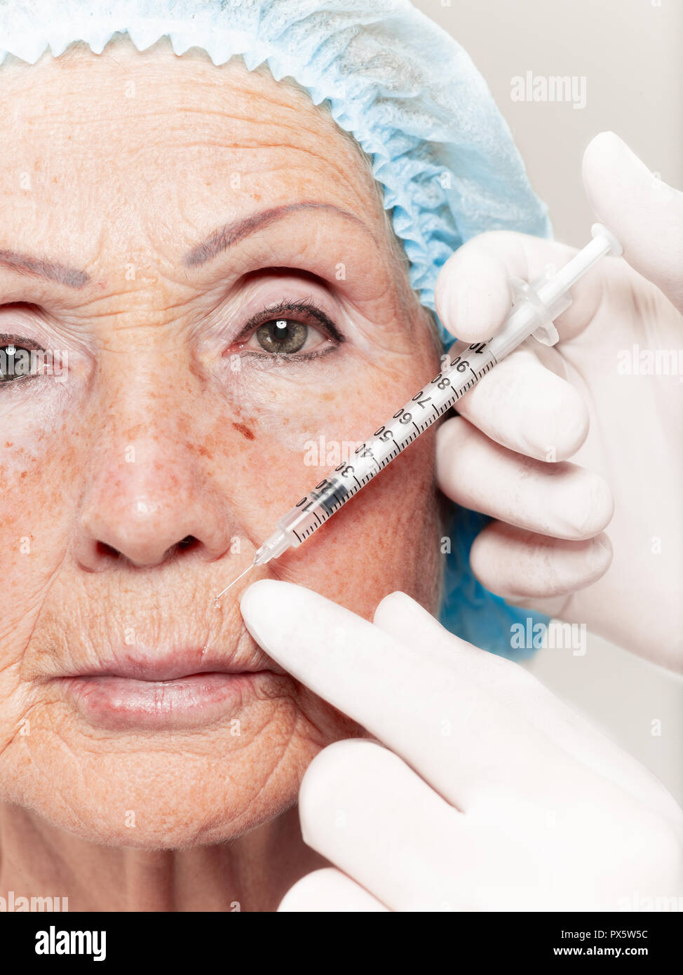 The surgeon doing skin check on mid age woman before plastic surgery ...