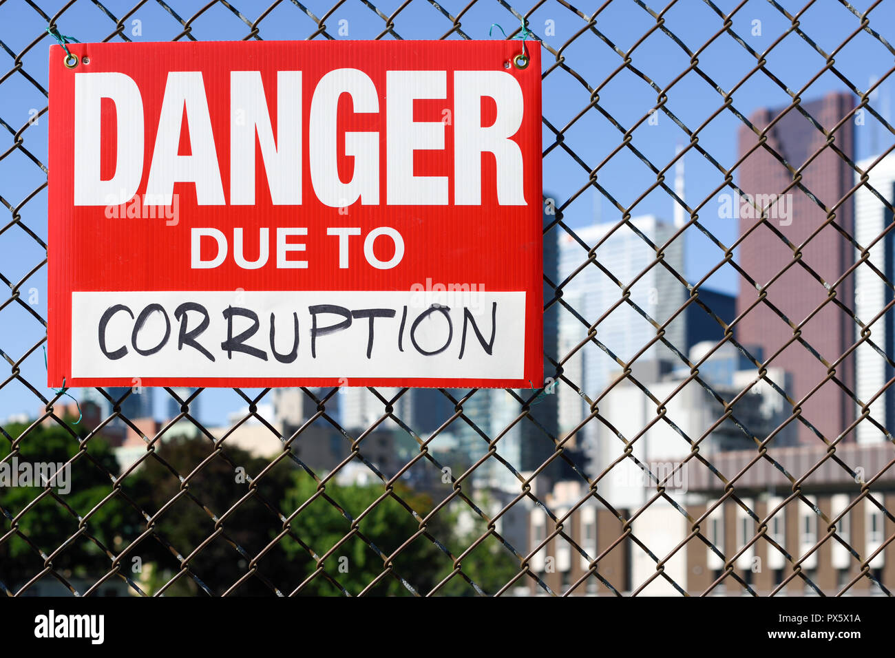 Sign danger due to corruption attached on the fence in the front of the ...