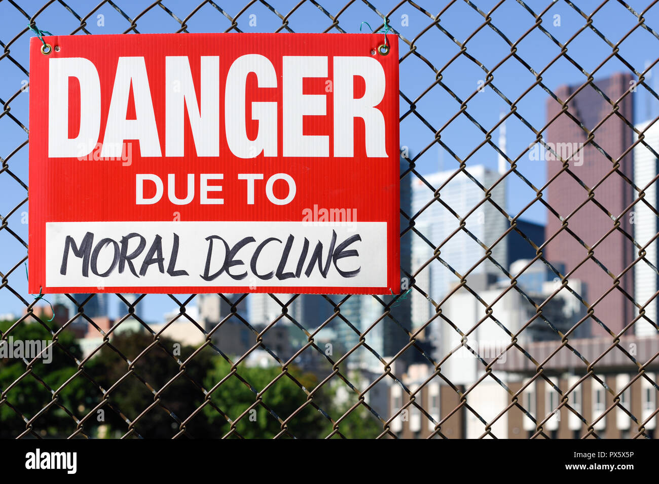 Sign danger due to moral decline attached on the fence in the front of ...
