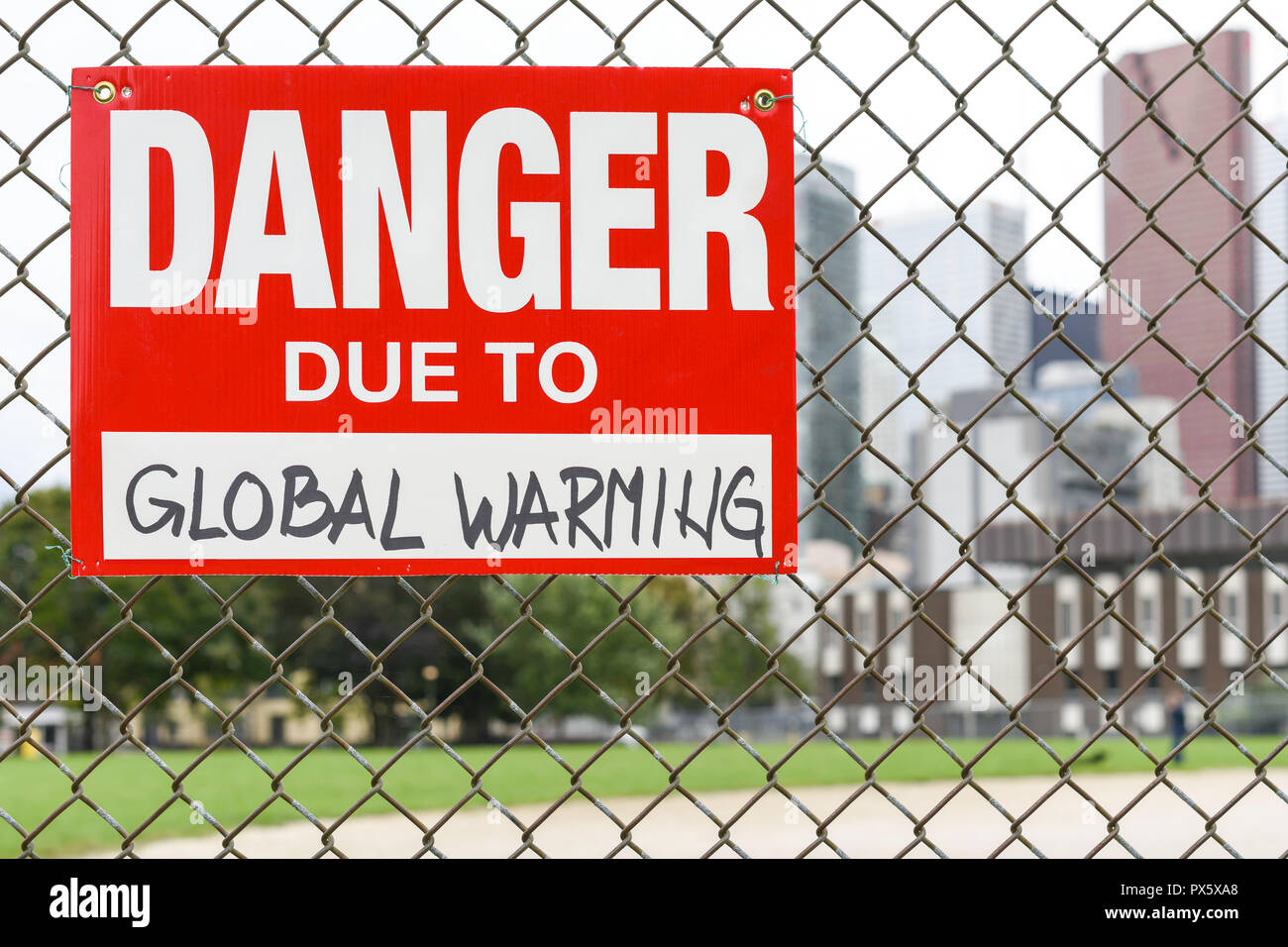 Sign danger due to global warming attached on the fence in the front of ...