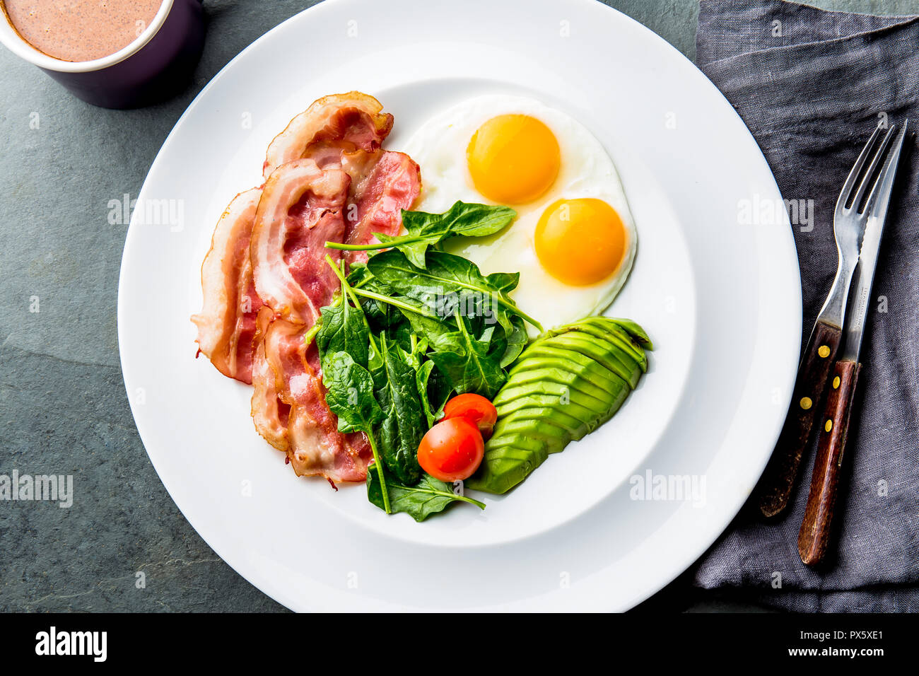 Ketogenic diet breakfast. fried egg, bacon and avocado, spinach and ...