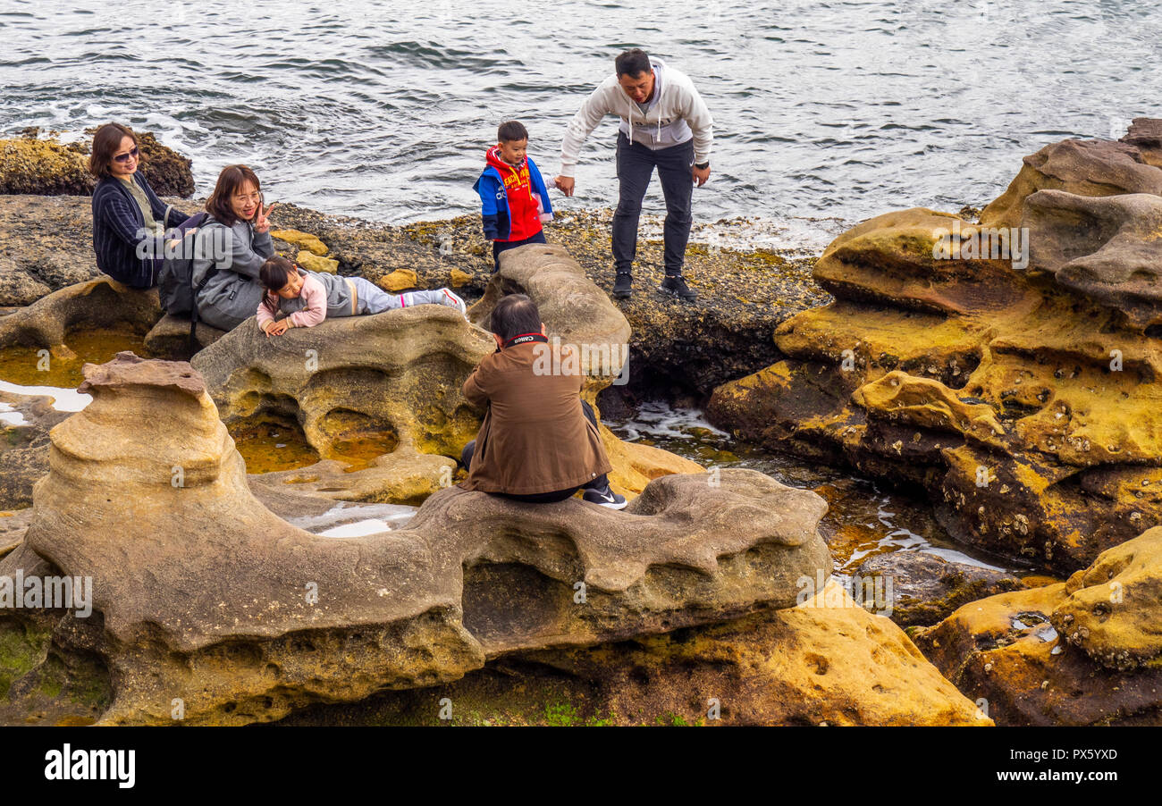 Asian tourists posing for photographs on sandstone rocks Farm Cove on ...