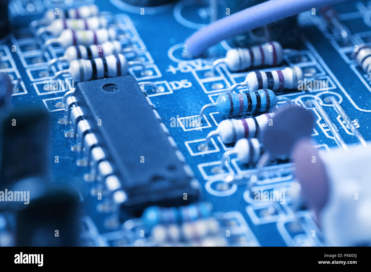 Microchip, capacitors, resistors on a blue computer board close-up ...