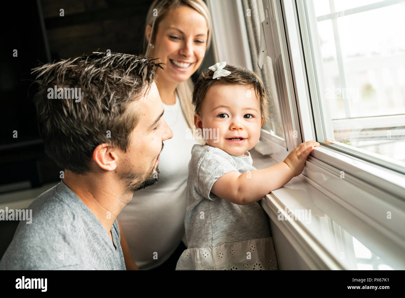 A family sit near window on the livingroom Stock Photo - Alamy