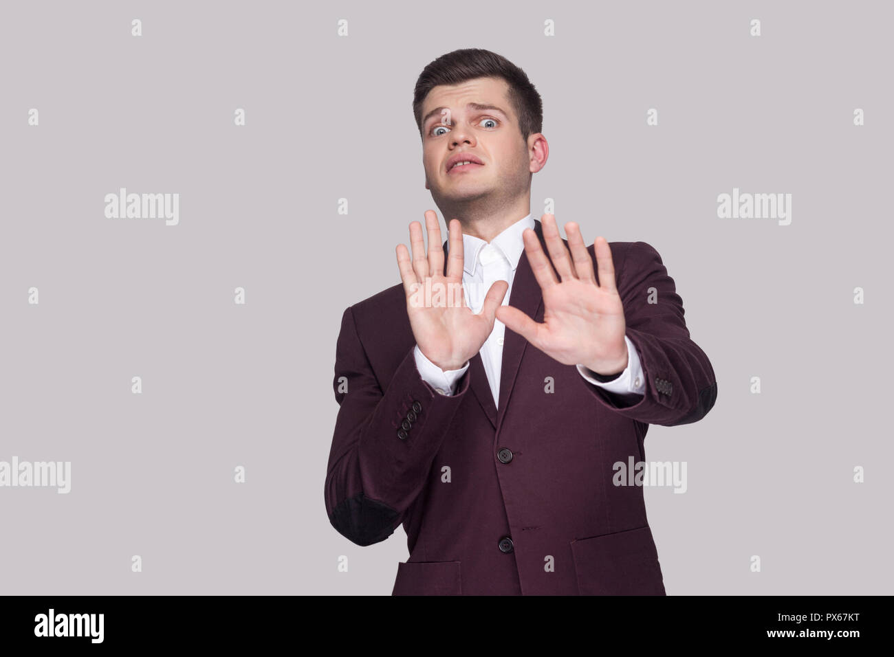 Please don't touch me. Portrait of scared handsome young man in suit ...