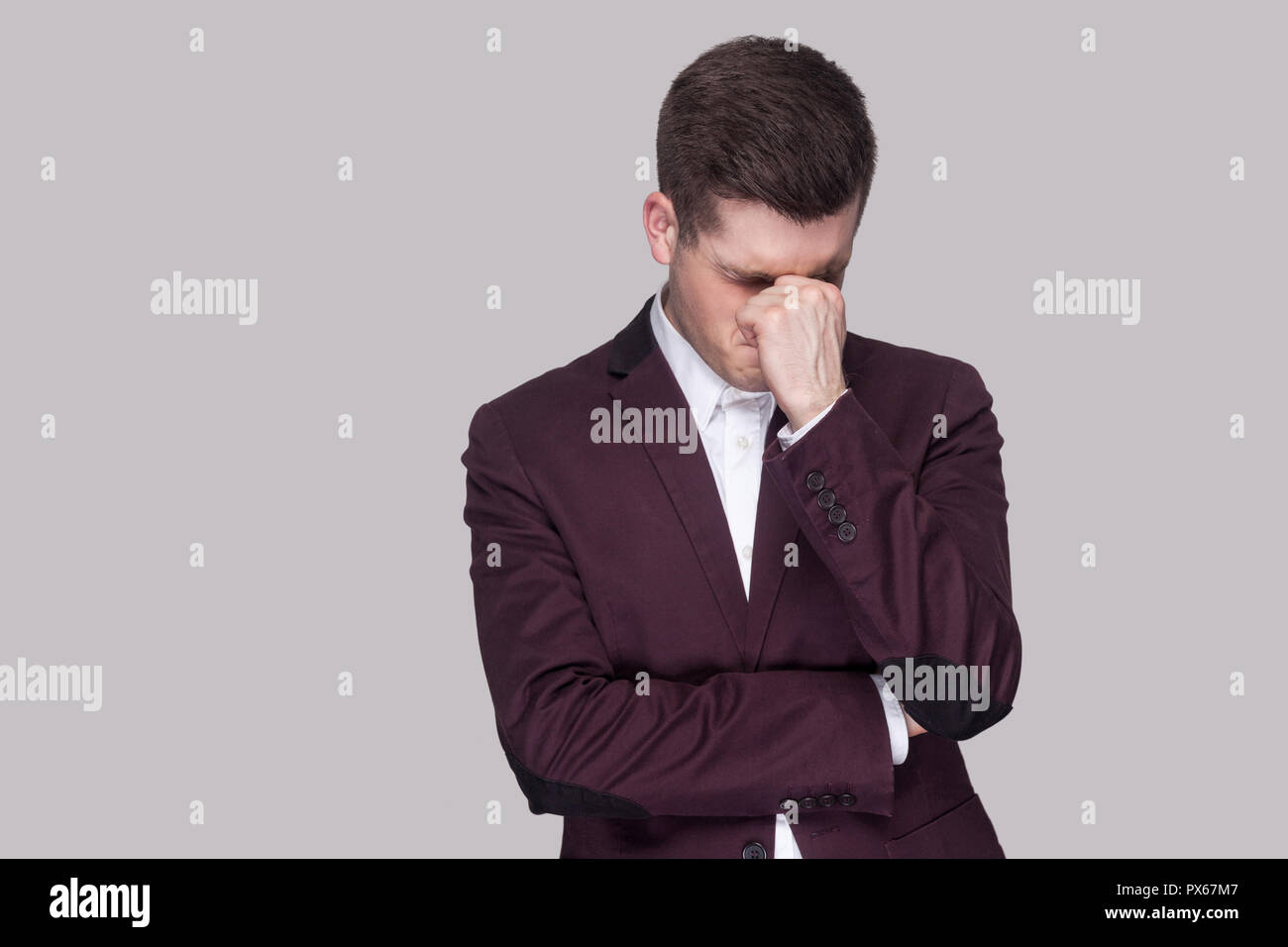 Portrait of sad depressed handsome young man in violet suit and white ...
