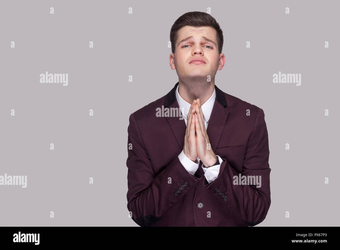 Portrait of pleasing worry handsome young man in violet suit and white ...