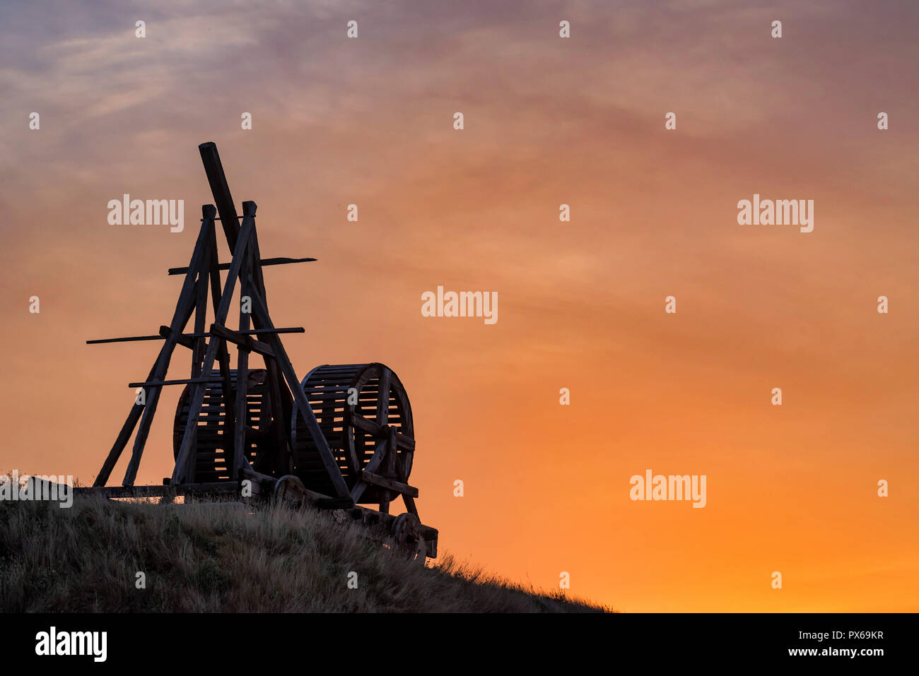 Old wooden catapult against sunset sky background Stock Photo - Alamy