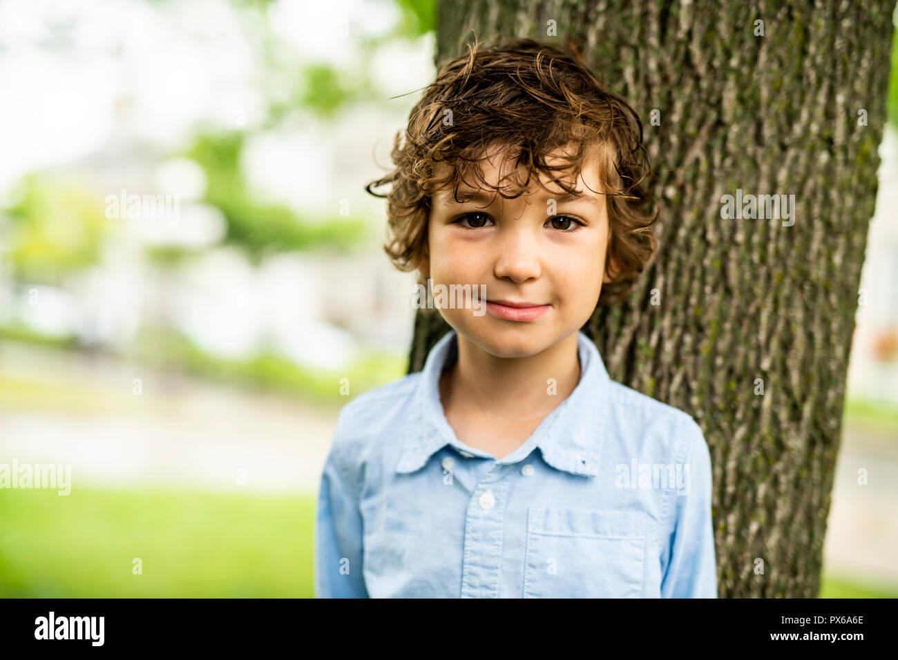 A Cute Caucasian boy happily close to a tree Stock Photo - Alamy