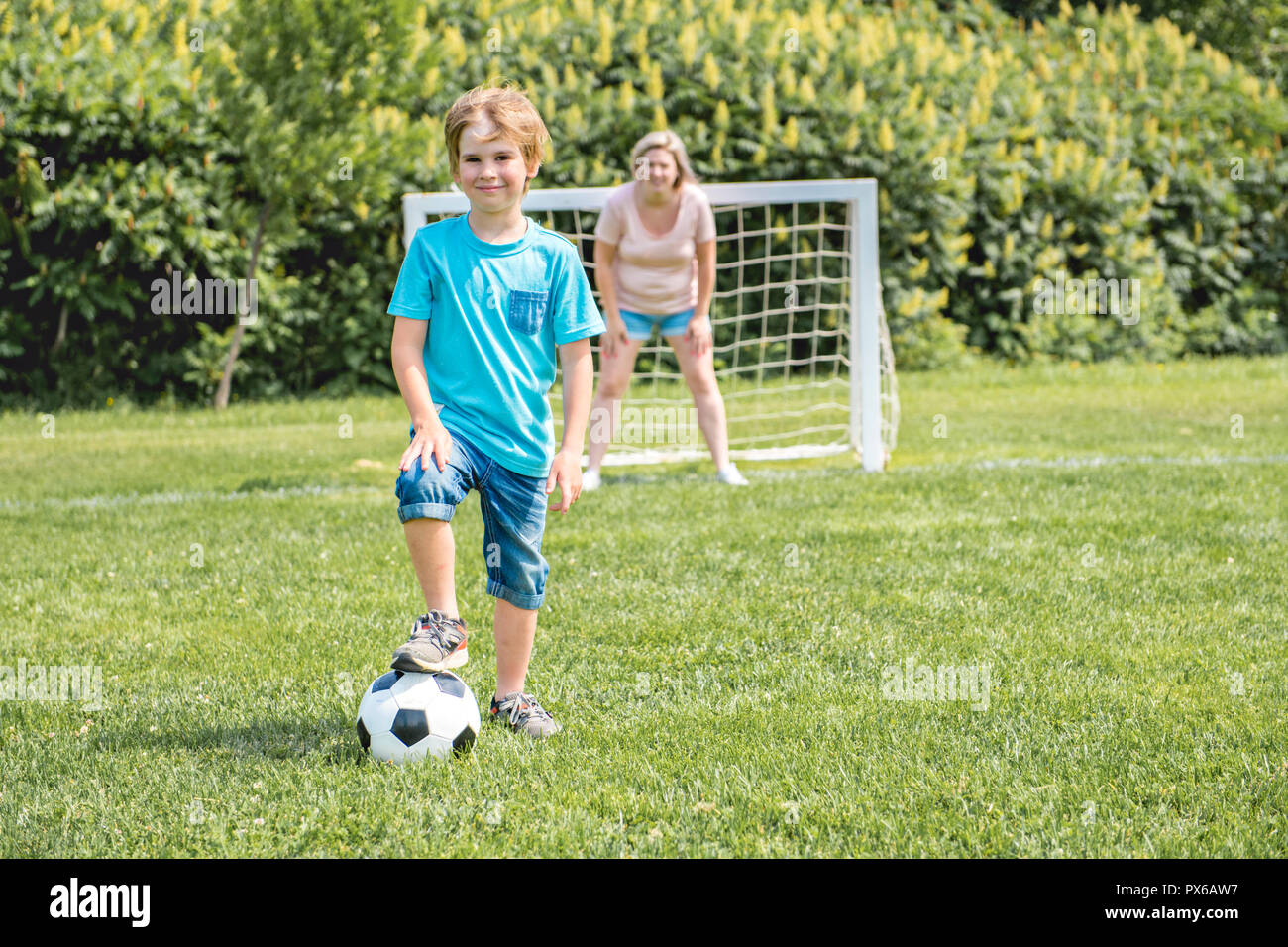 A man with child playing football outside on field Stock Photo - Alamy
