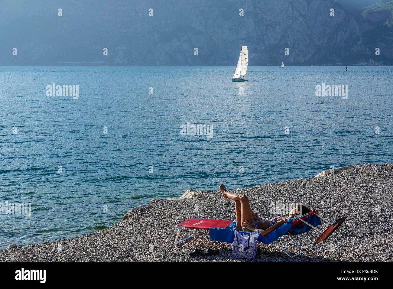 Cassone, Garda Lake, Italy. Female tourist relaxing and sunbathing in a ...