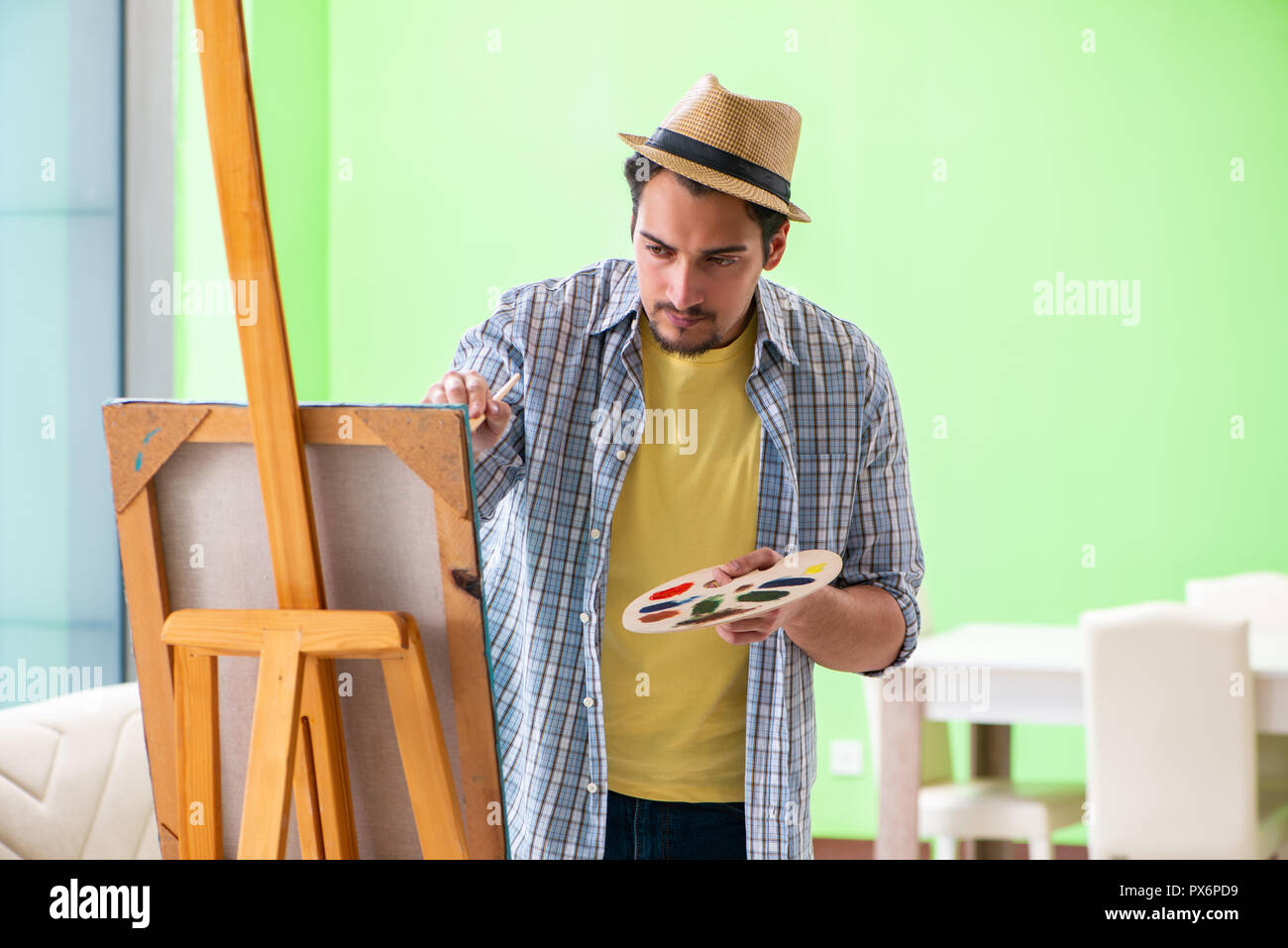 Young male artist working on new painting in his studio Stock Photo - Alamy