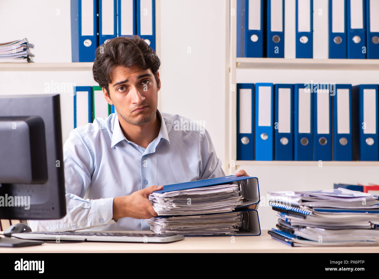 Overloaded busy employee with too much work and paperwork Stock Photo ...