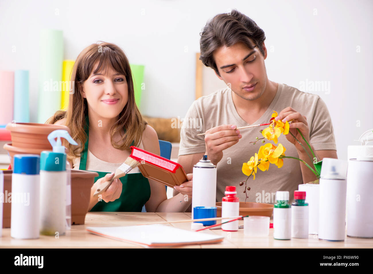 Couple decorating pots in workshop during class Stock Photo - Alamy