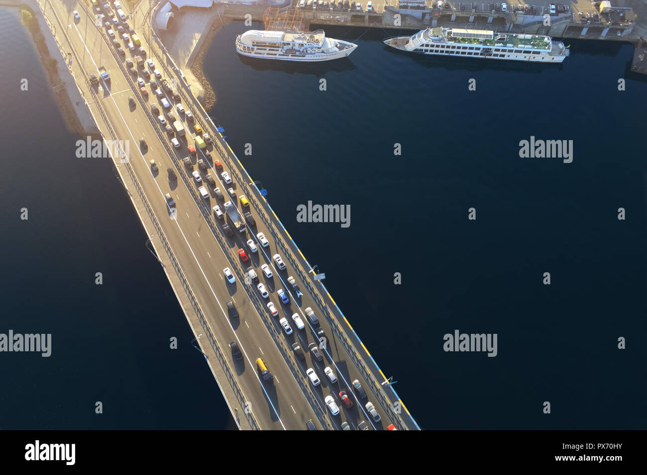 Aerial view of road bridge across river with heavy traffic jam in one ...