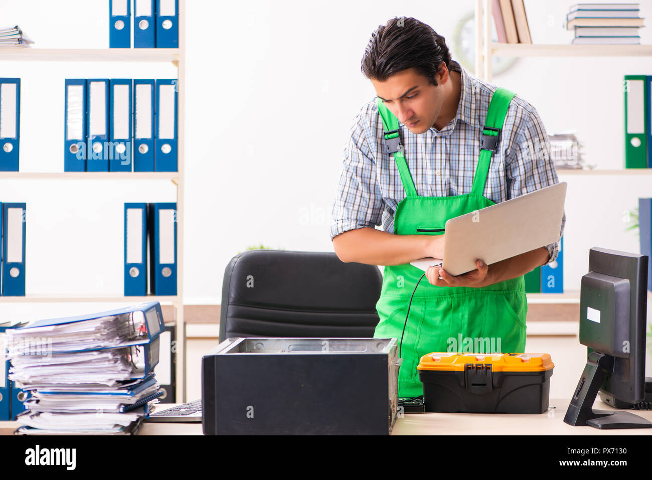 Young engineer repairing broken computer at the office Stock Photo - Alamy